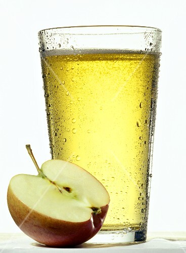 Ein Glas Apfelsaftschorle, davor ein halber Apfel – Bild kaufen ...